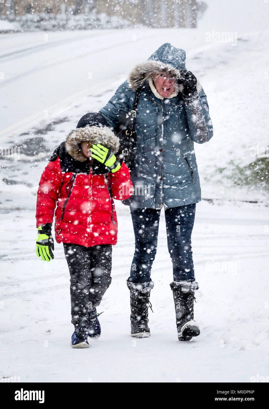 People shield their faces in snowy conditions in Hawes in the Yorkshire ...