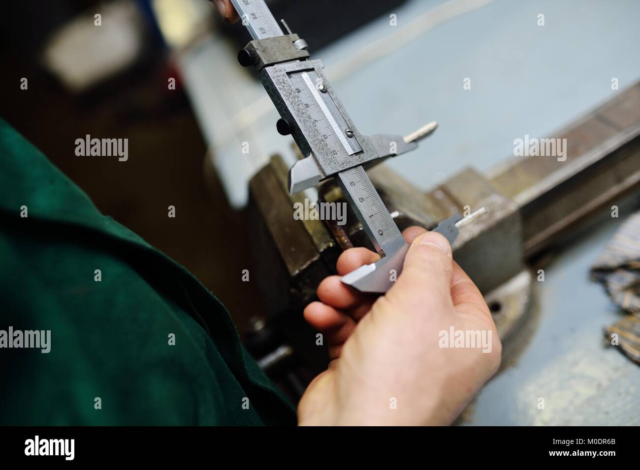worker holds a caliper in her hands and measures a detail Stock Photo ...