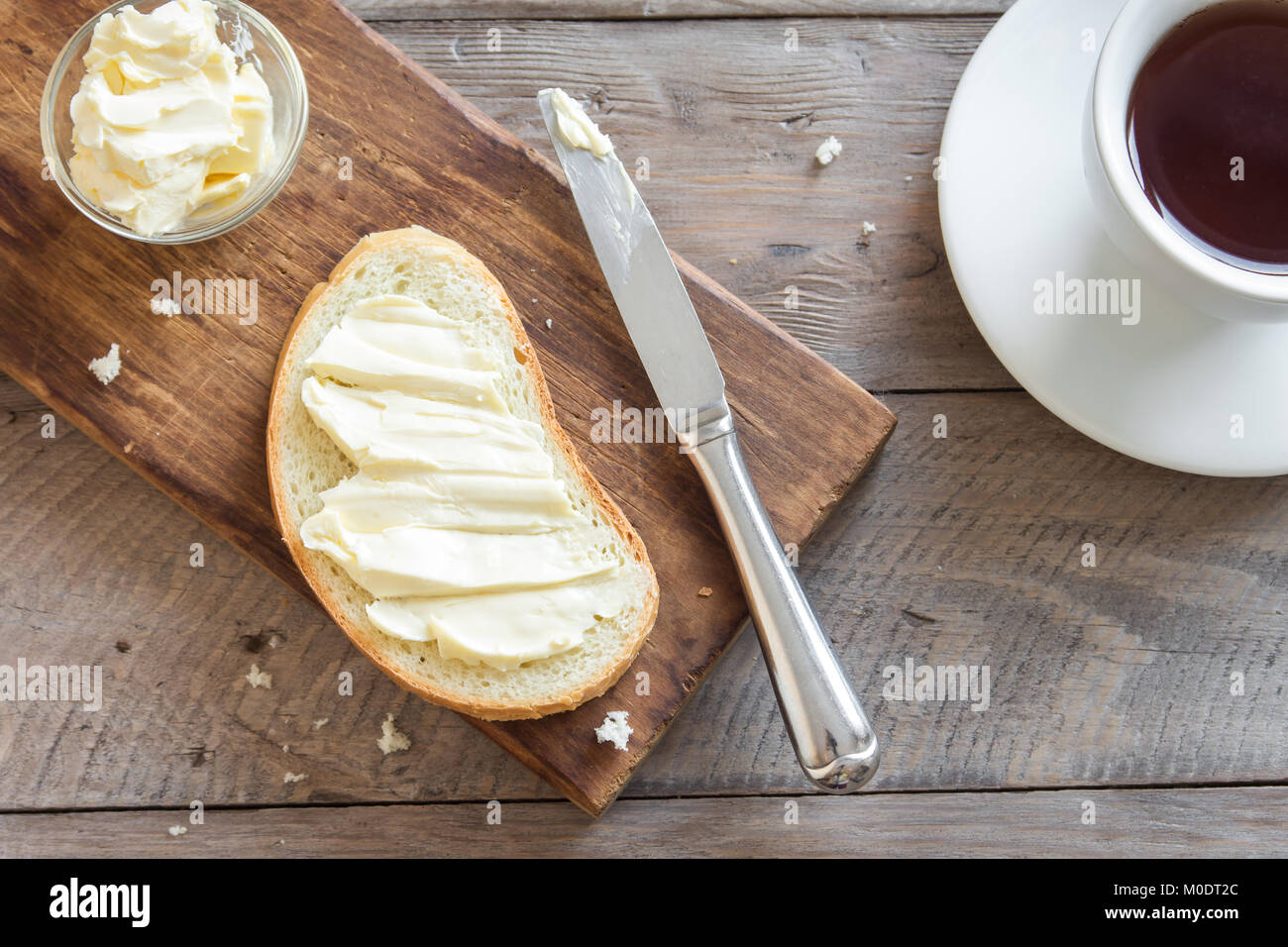 Butter and bread for breakfast, with cup of coffee over rustic wooden ...