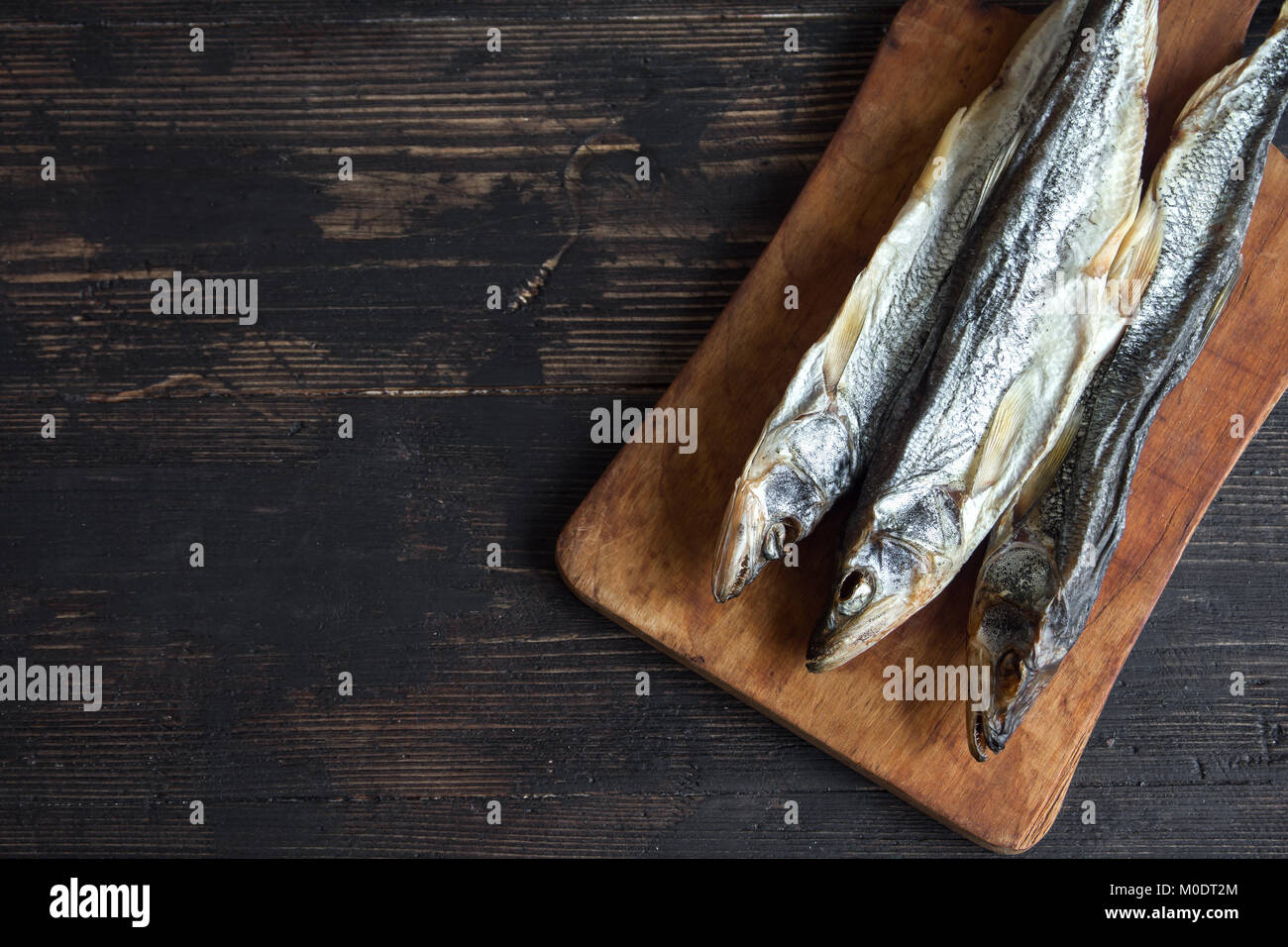 Sun dried fish, salted smelts over wooden background, top view, copy ...
