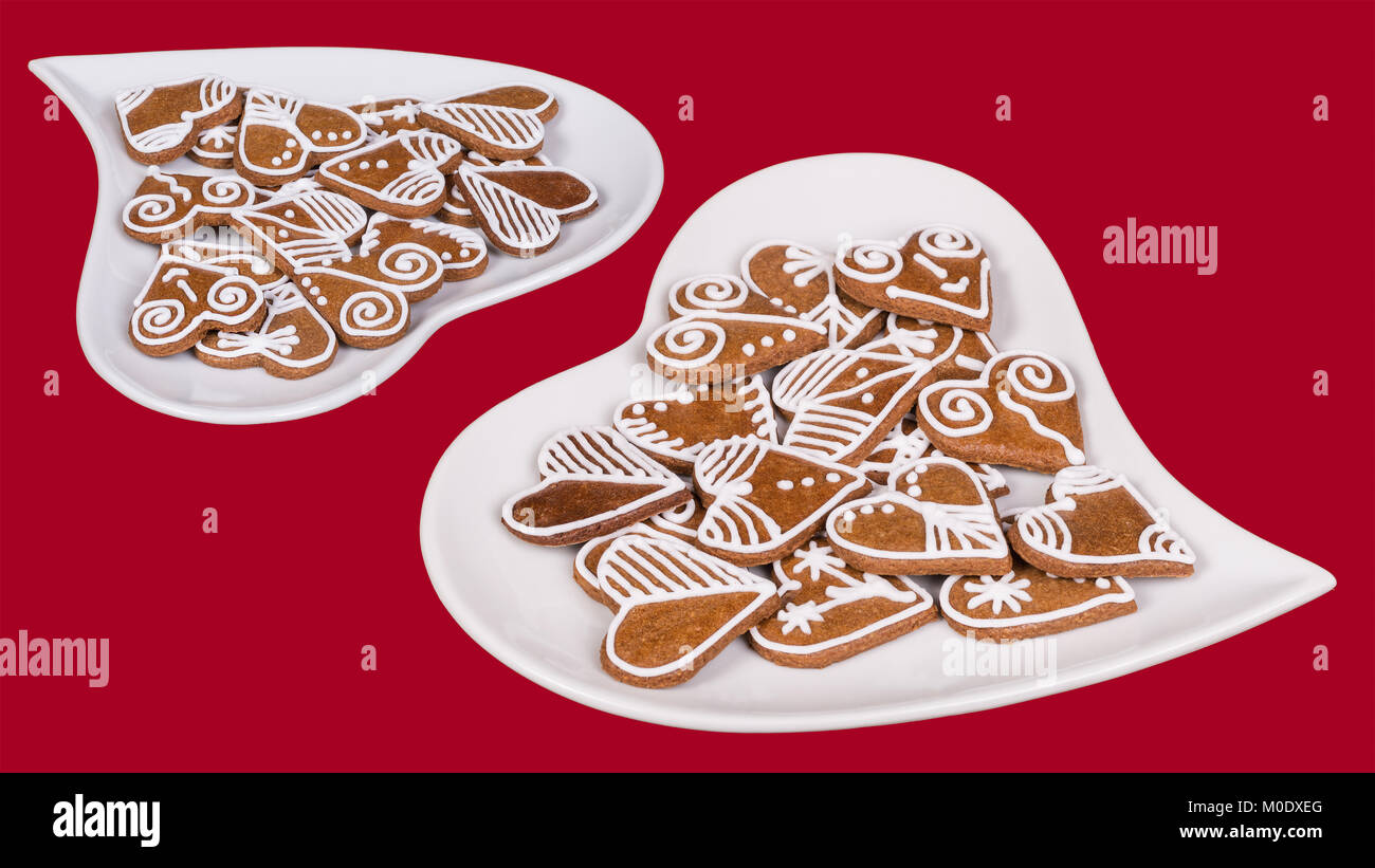 Heap of ornate gingerbread hearts on twoo white heart-shaped plates ...