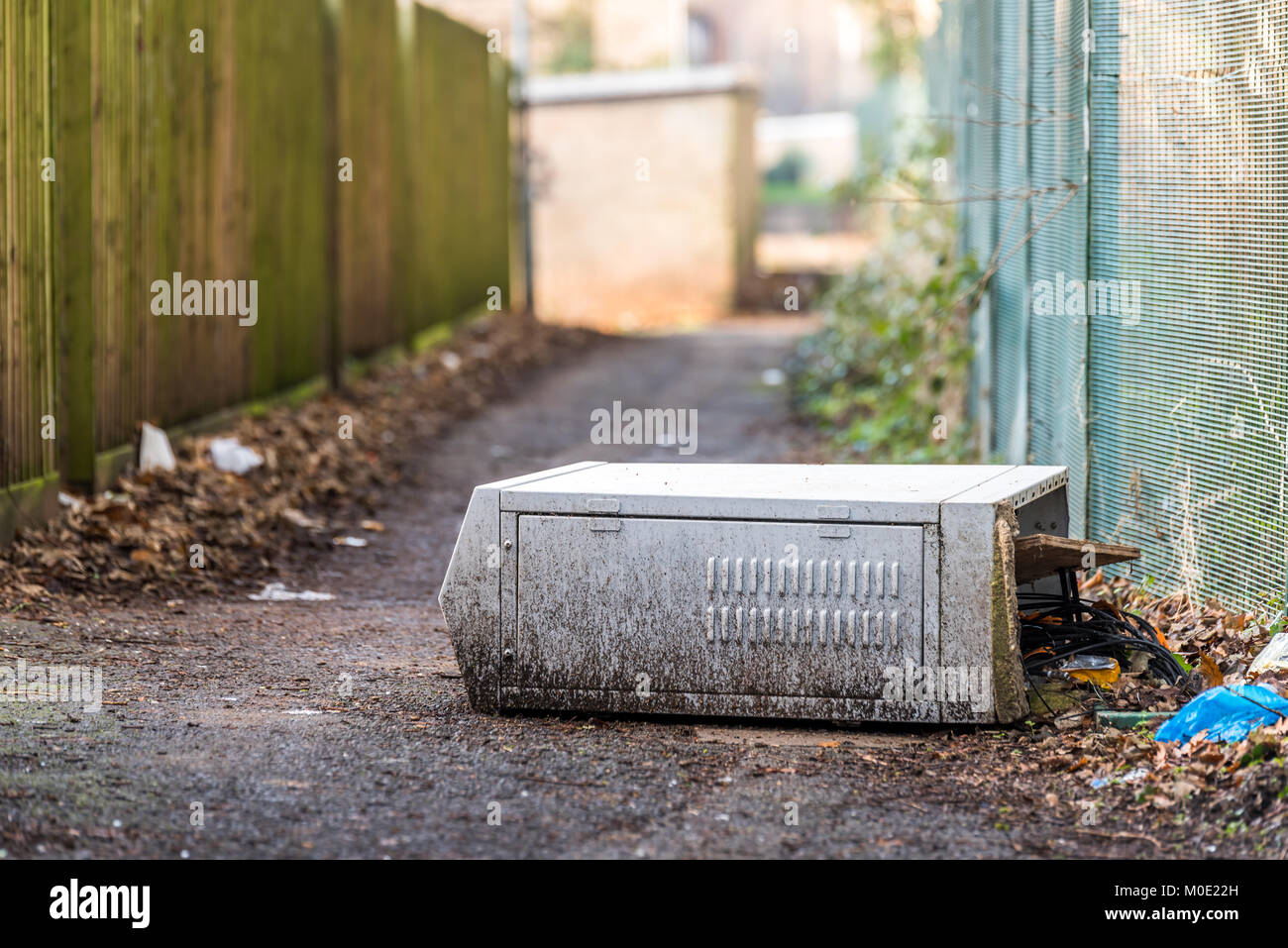 Fallen broken electrical box outdoors on footpath with cable wires ...