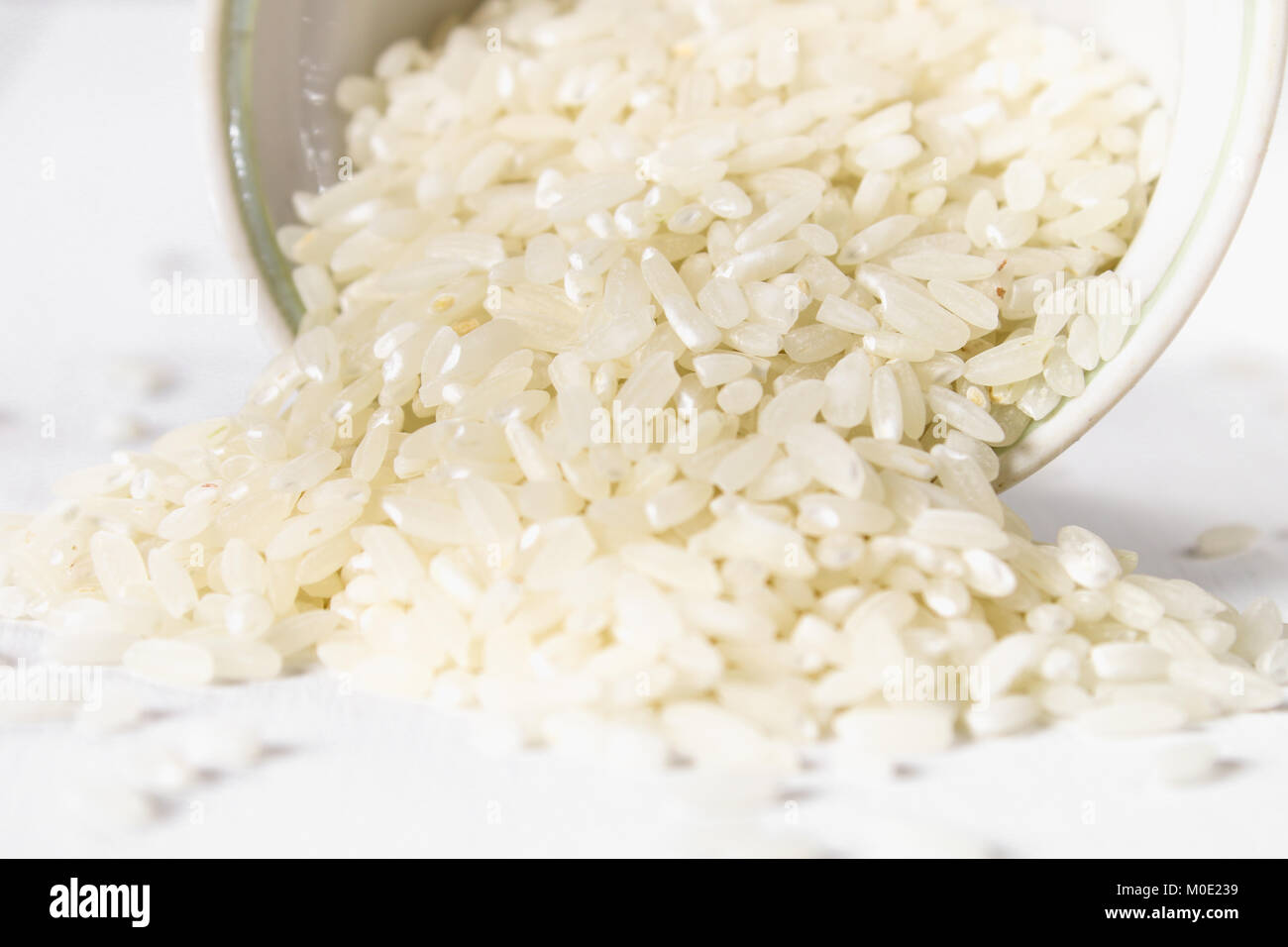 Grains of raw white rice on a white wooden table of boards. Ingredients ...