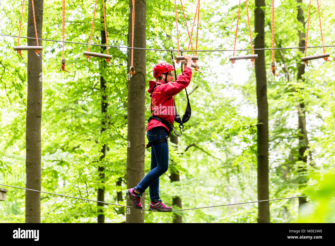 Child reaching platform climbing in high rope course Stock Photo - Alamy