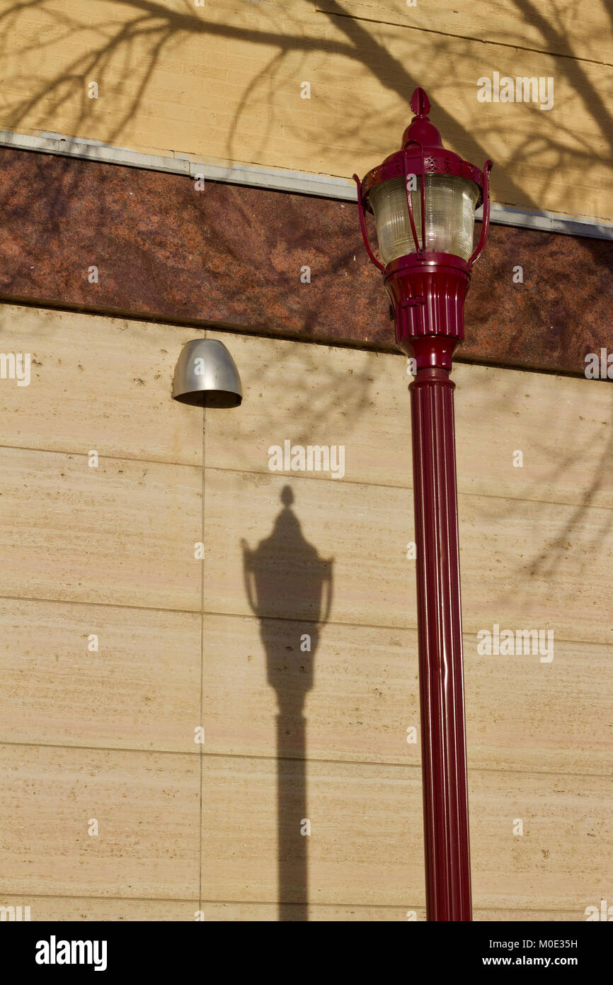 Upward view of Red city street lamp with shadow cast upon a light color ...