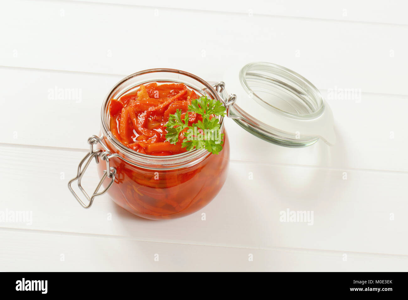 jar of pickled red peppers on white wooden background Stock Photo - Alamy