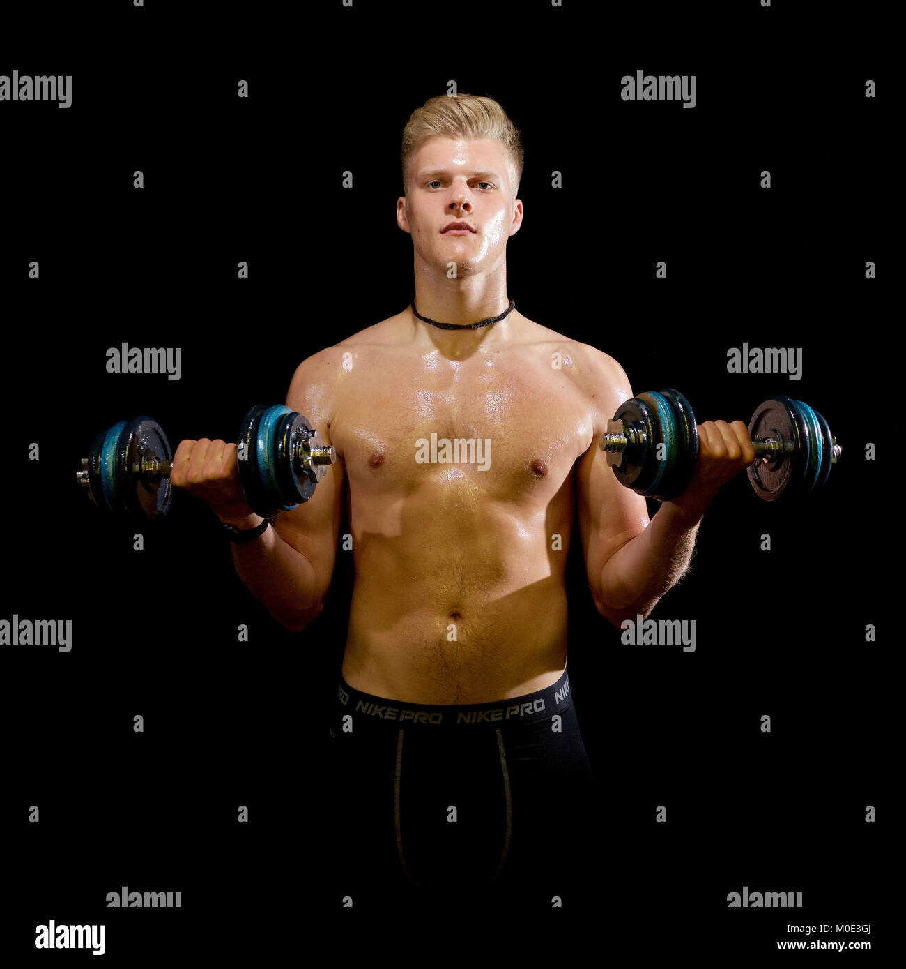 Young man keeping fit against a black background Stock Photo - Alamy