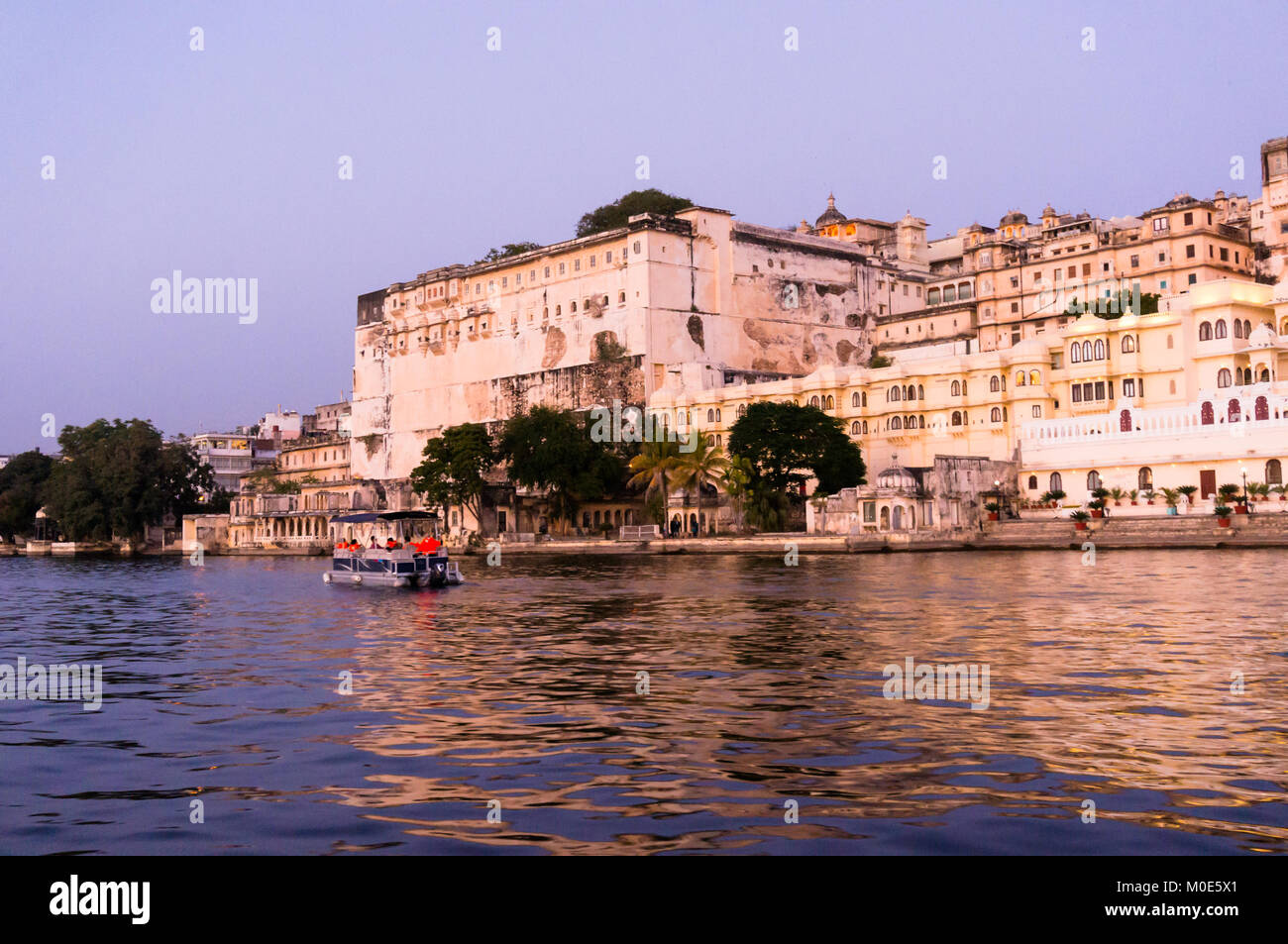 Udaipur city palace as seen from a boat on lake pichola at dusk with ...