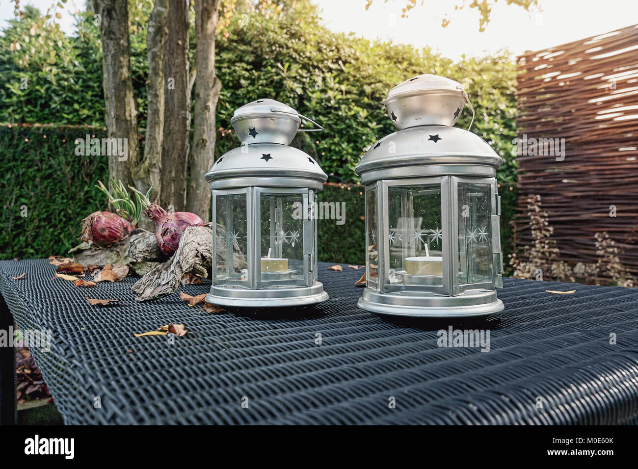 For decoration three candle holders on the table in the garden Stock ...