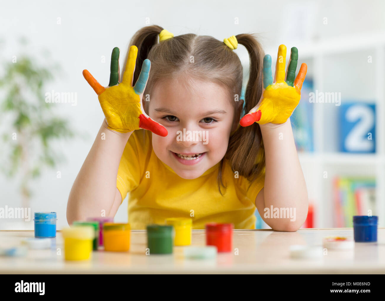 cute child girl have fun painting her hands in preschool Stock Photo ...