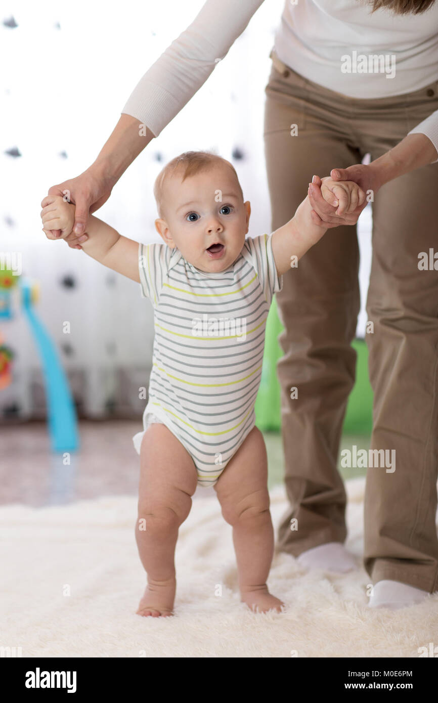 smiling baby boy walking hand in hand with mom Stock Photo - Alamy
