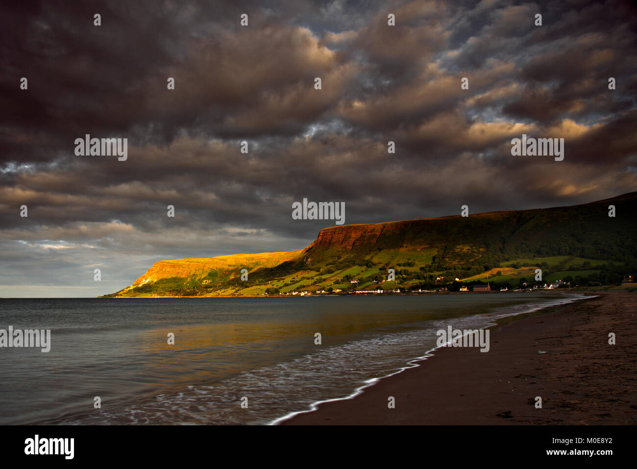 The beach at Waterfoot, Northern Ireland with sunlight and shadow Stock ...