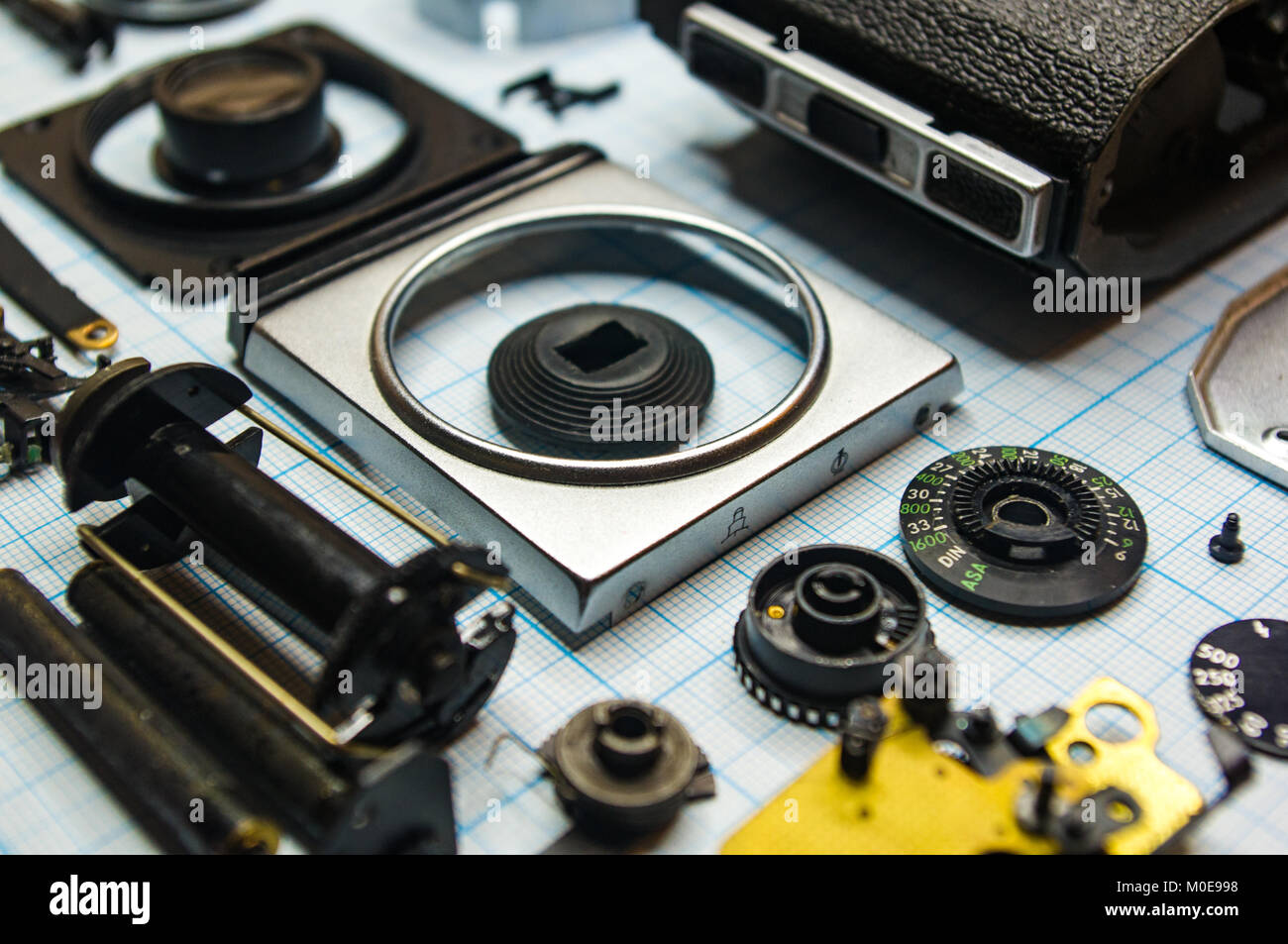 parts are completely disassembled old retro film SLR camera on graph ...