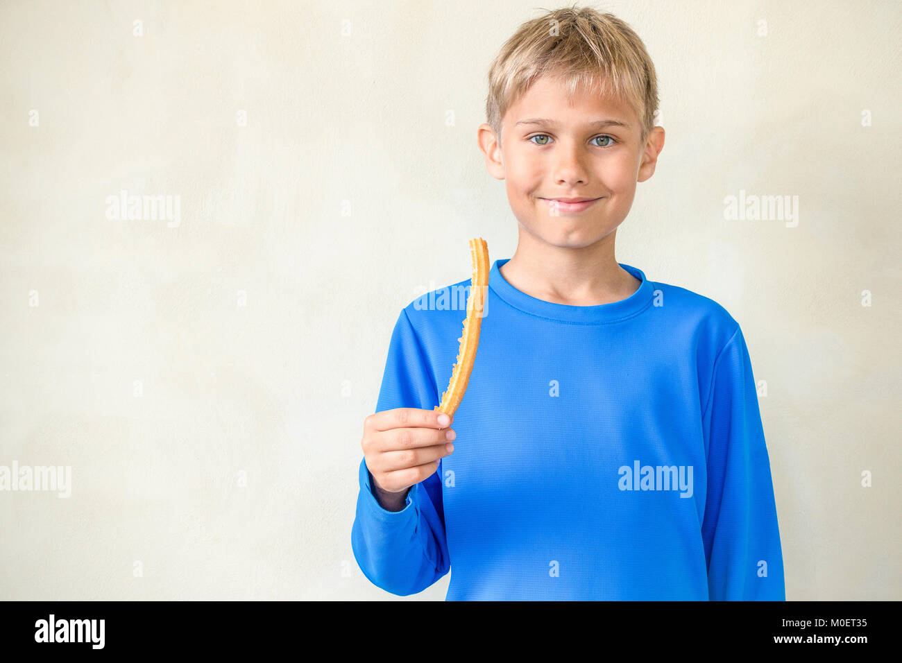 Smiling boy with famous Spanish dessert churros Stock Photo - Alamy