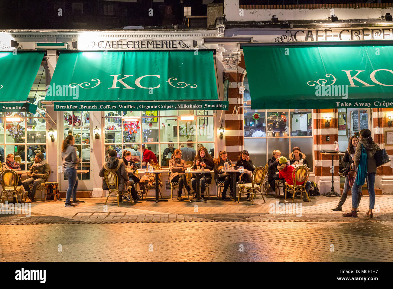 People eating outside cafe in evening, Kensington, London, UK Stock ...