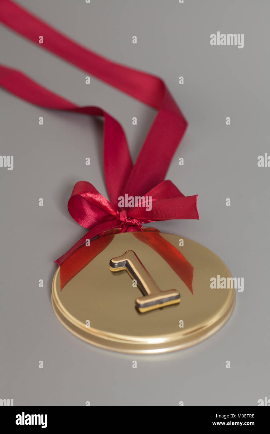 Champion Gold Medal with red ribbon on gray background Stock Photo - Alamy