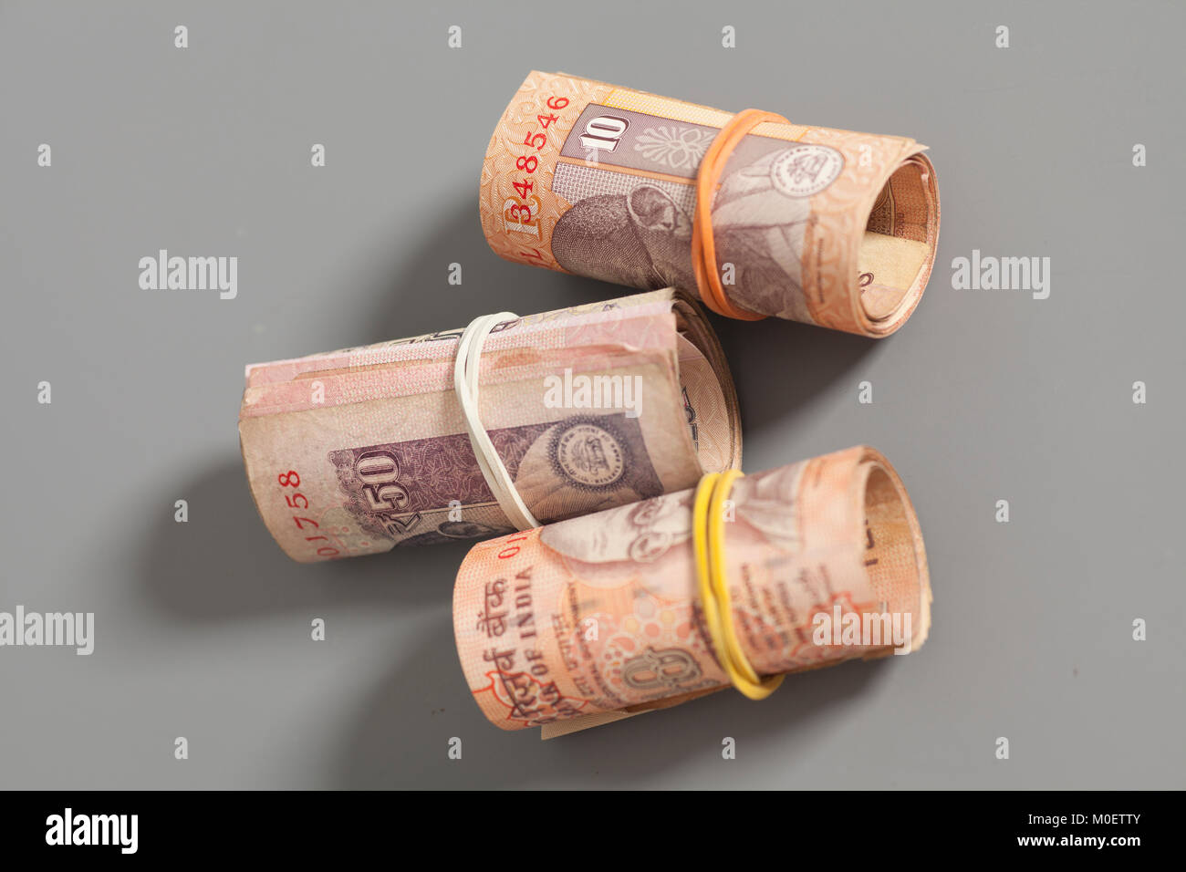Rolls of Indian rupees on a gray background Stock Photo - Alamy