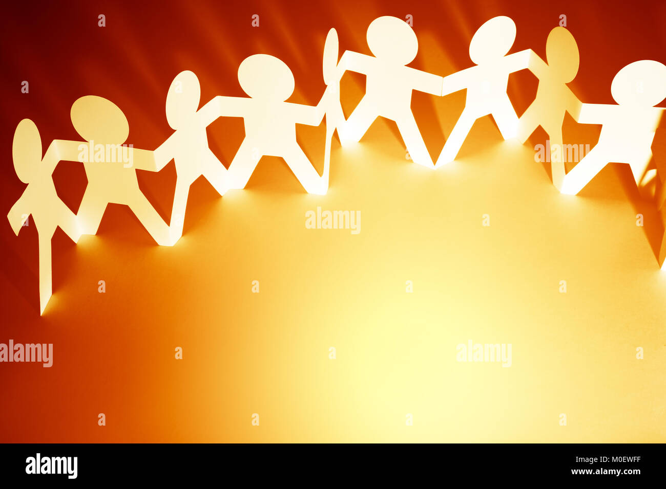 Team of paper chain people in a row holding hands. Copy space Stock ...