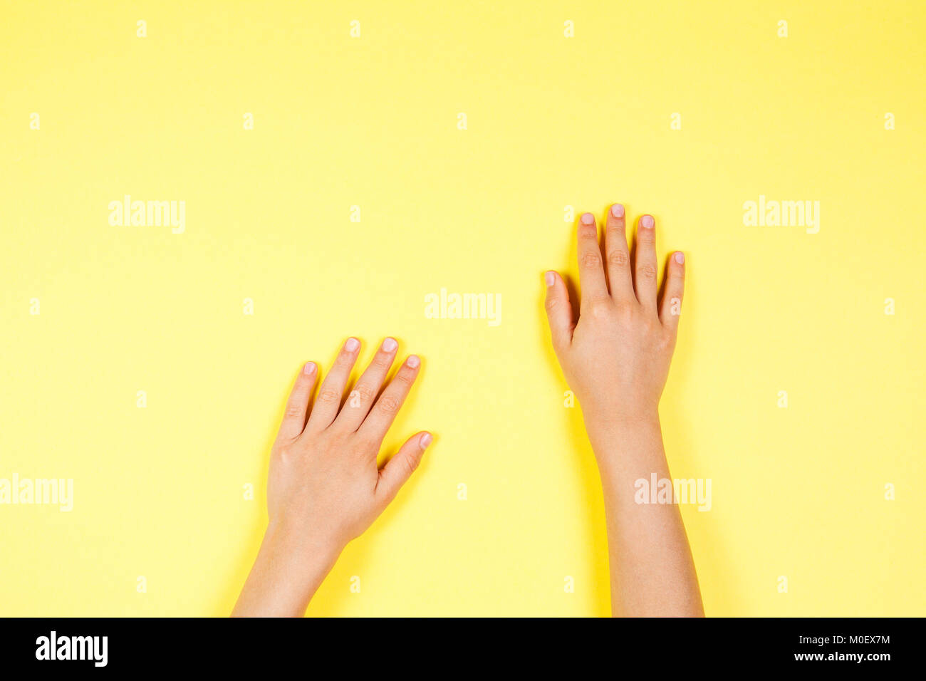 two children hands on yellow background Stock Photo - Alamy