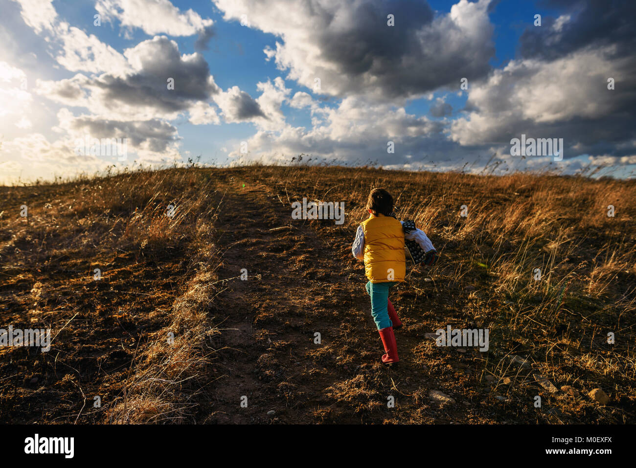 Boy running through a field Stock Photo - Alamy