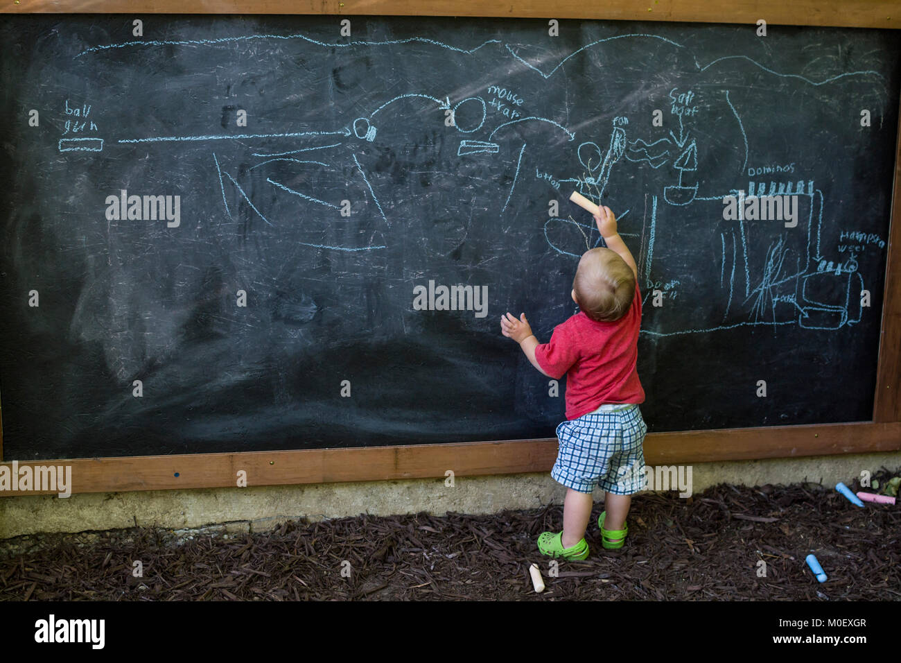 Boy drawing on a chalk blackboard Stock Photo - Alamy