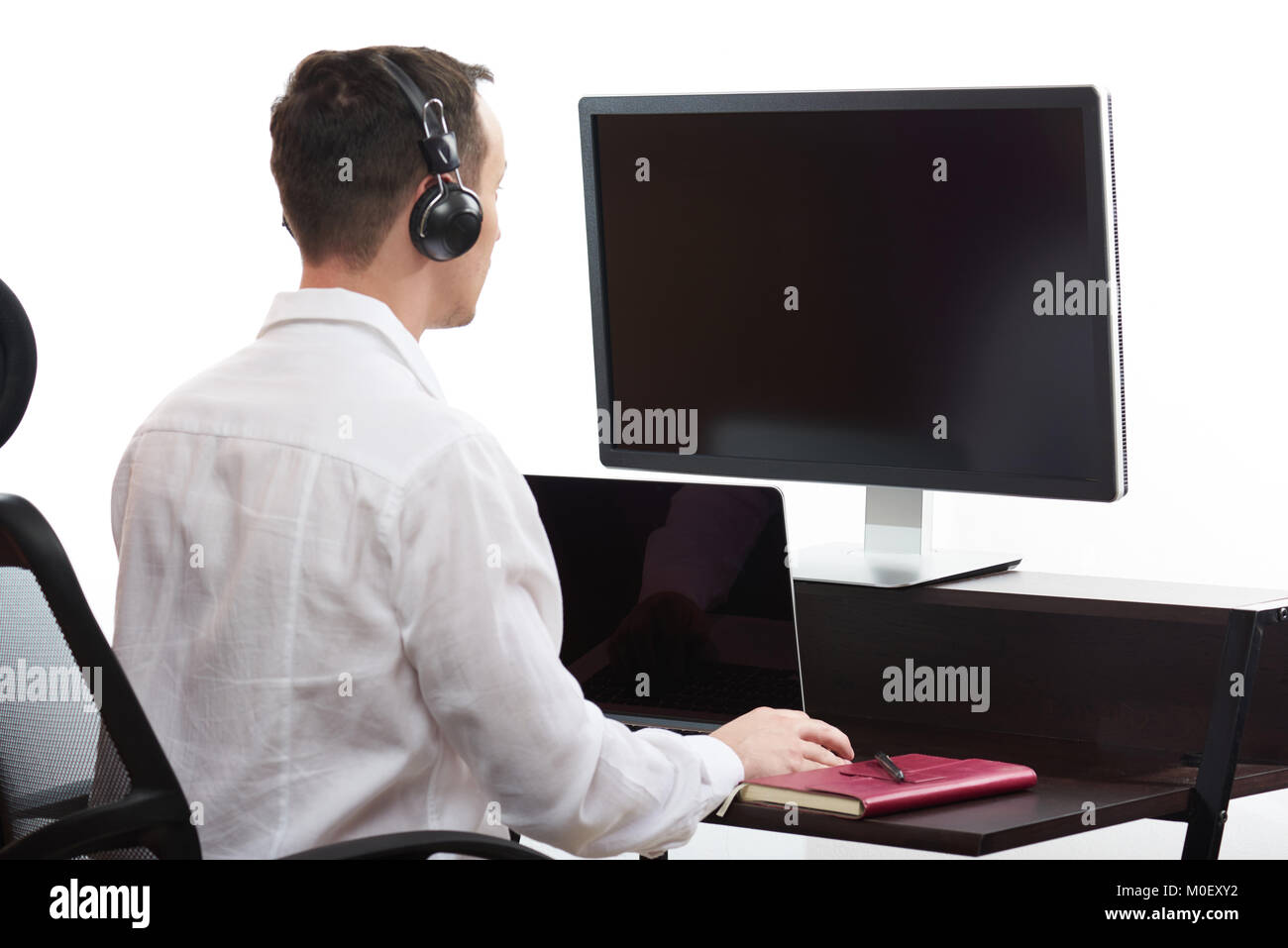 Young man working in office with big computer screen. One man on ...