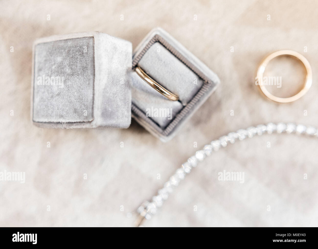 Two wedding rings and a bracelet Stock Photo - Alamy