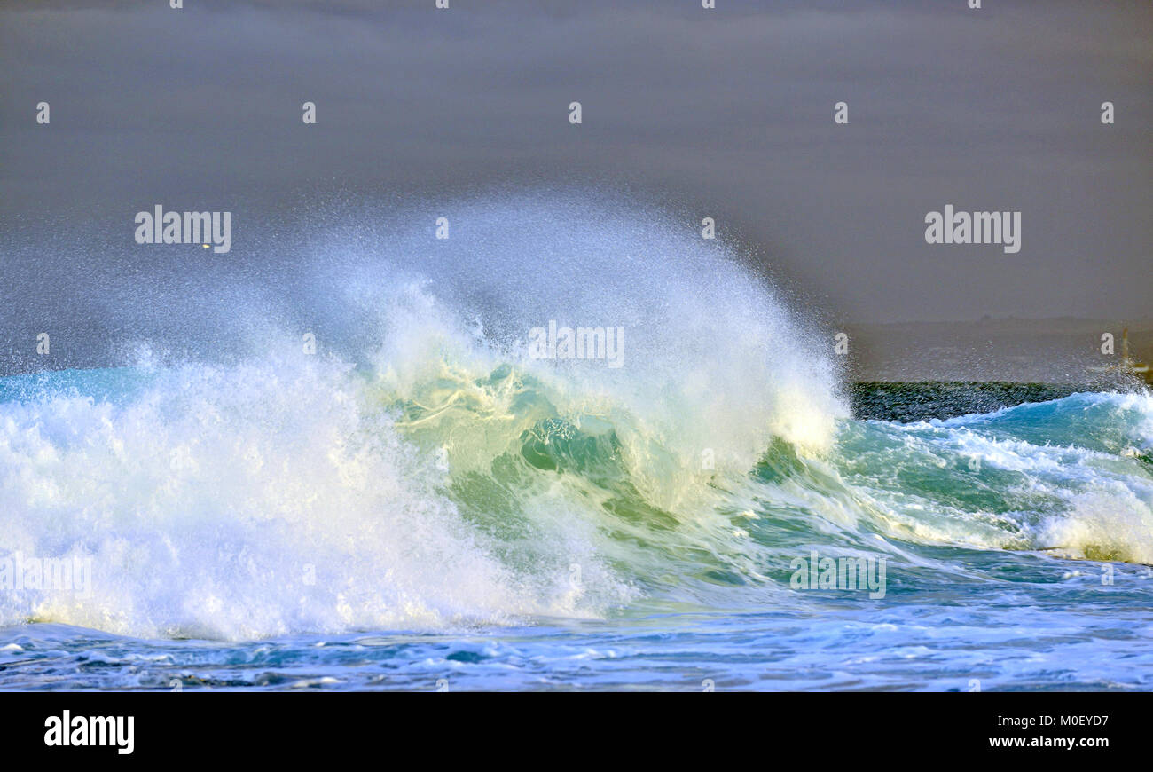Splashing into a spray wave against a stormy sky. Powerful ocean wave ...