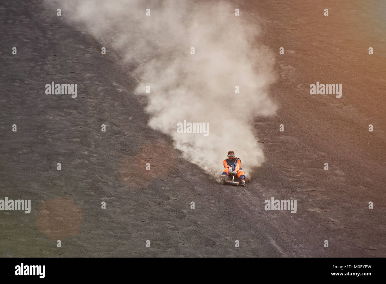 Speed ride on volcano boarding in Nicaragua. Woman descend from volcano ...