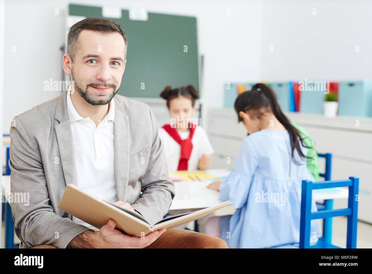 Teacher with book Stock Photo - Alamy