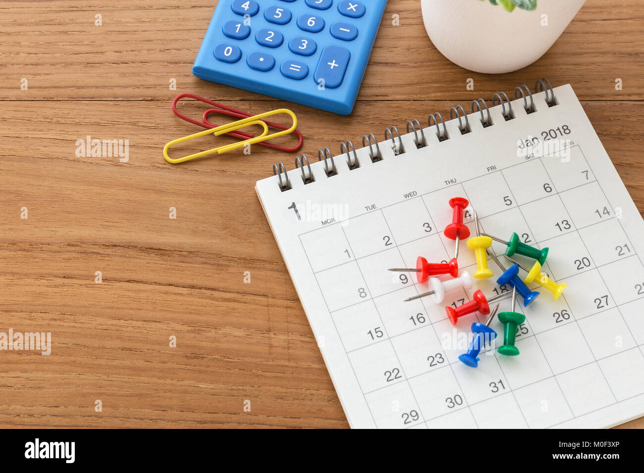 Calendar with pins on wooden table with space Stock Photo - Alamy
