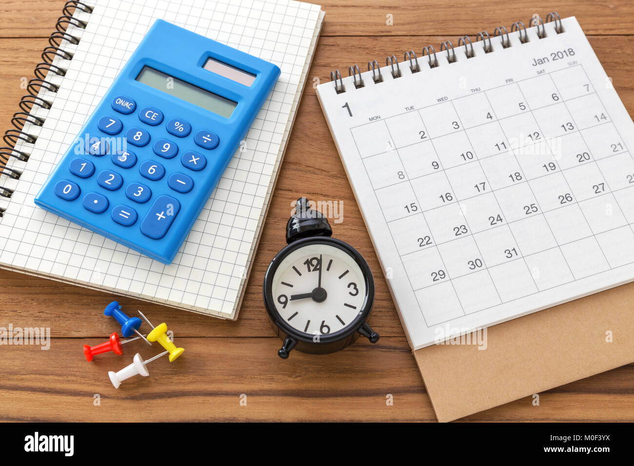 Calendar with calculator and clock on wooden table Stock Photo - Alamy