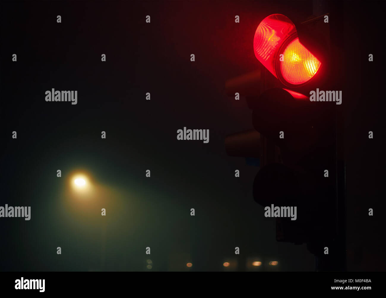 Closeup view of semaphore, red light and foggy night atmosphere Stock ...
