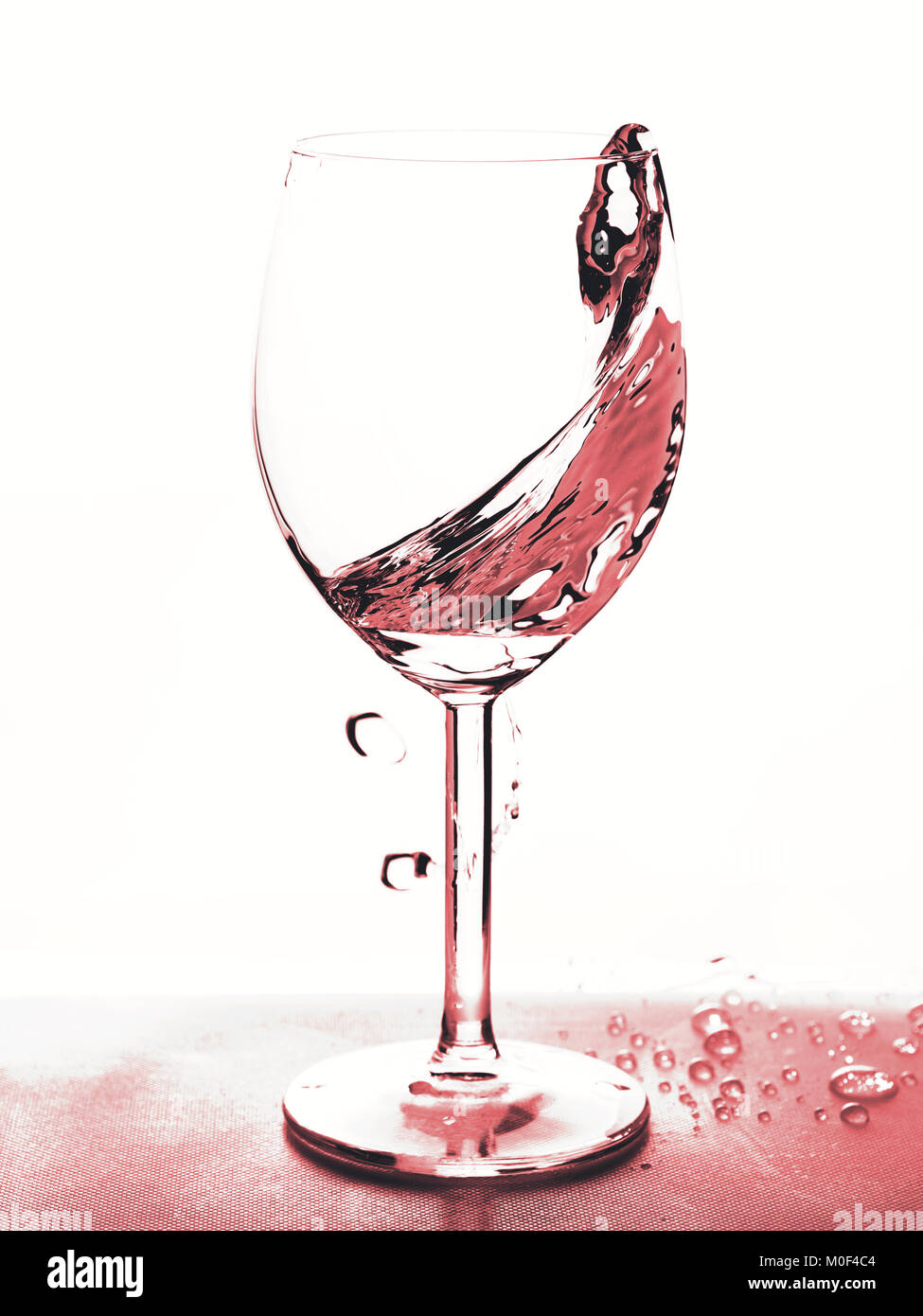 Half empty glass with water splashes in motion on white background ...