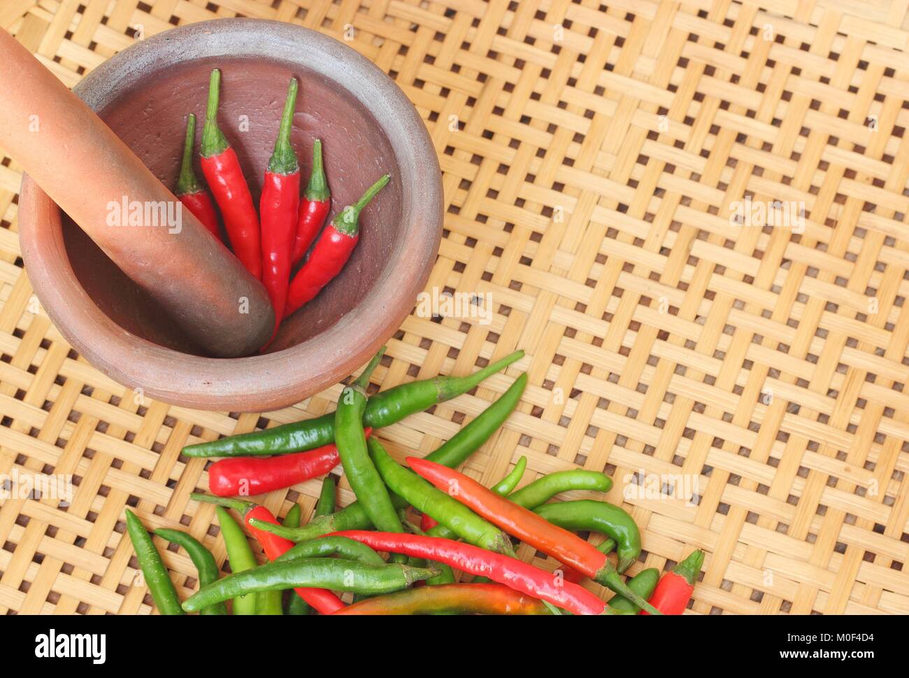 chili in mortar on wooden textured basket weaving background Stock ...