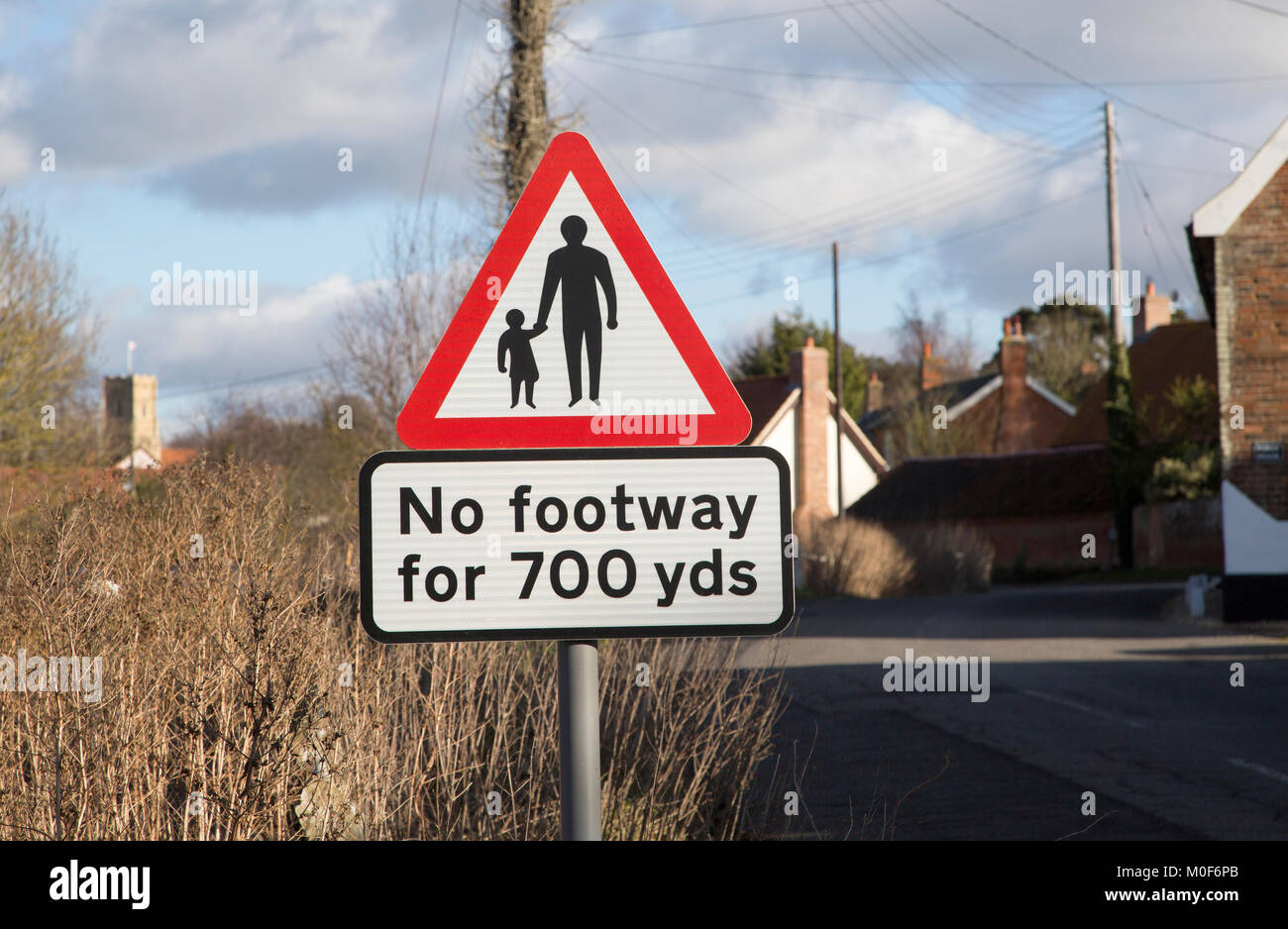 Red triangle road sign warning of no footway for 700 yards in village ...