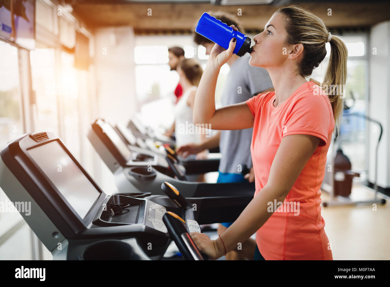 Group of friends exercising on treadmill machine Stock Photo - Alamy