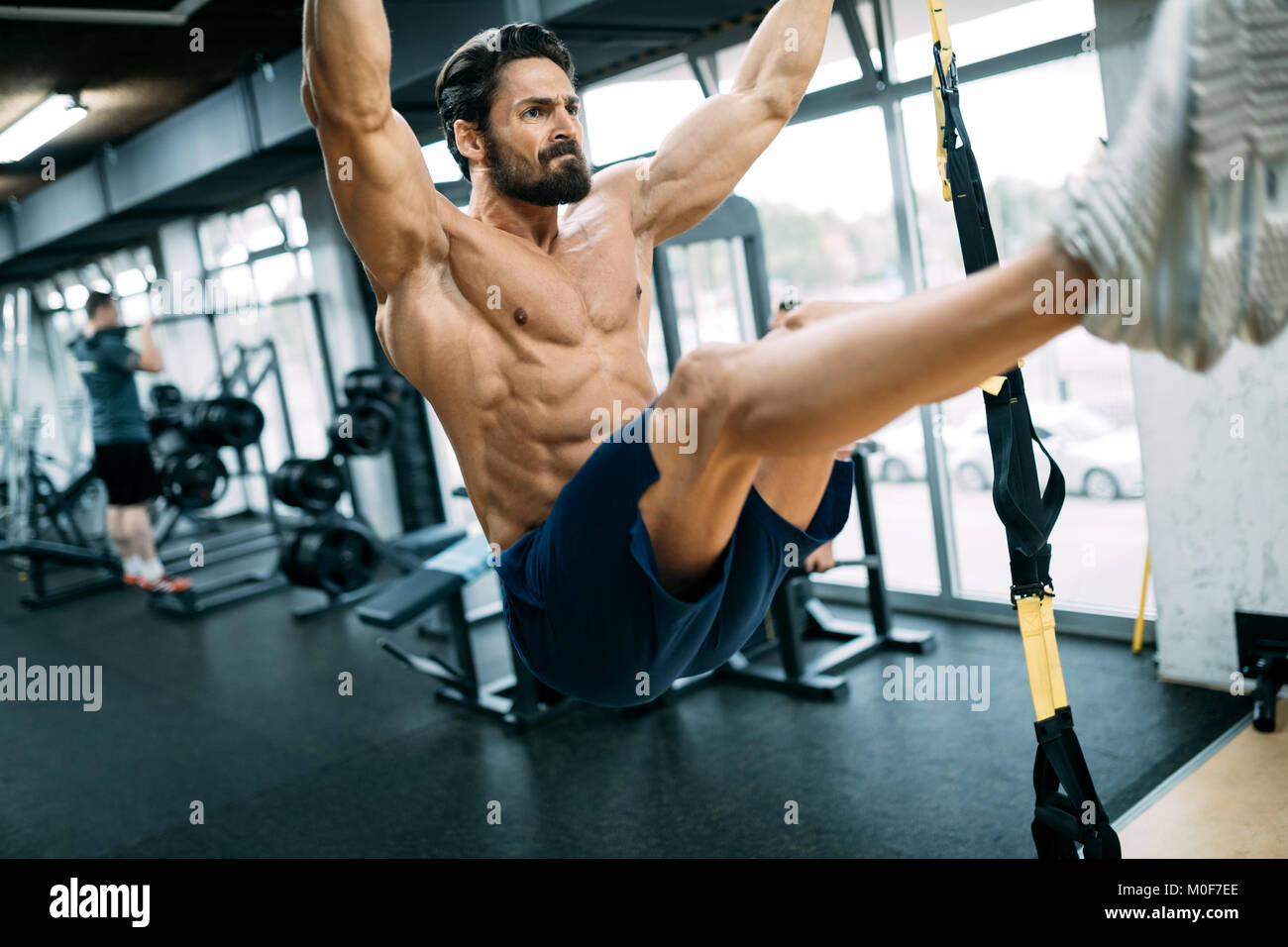 Young handsome man doing exercises in gym Stock Photo - Alamy