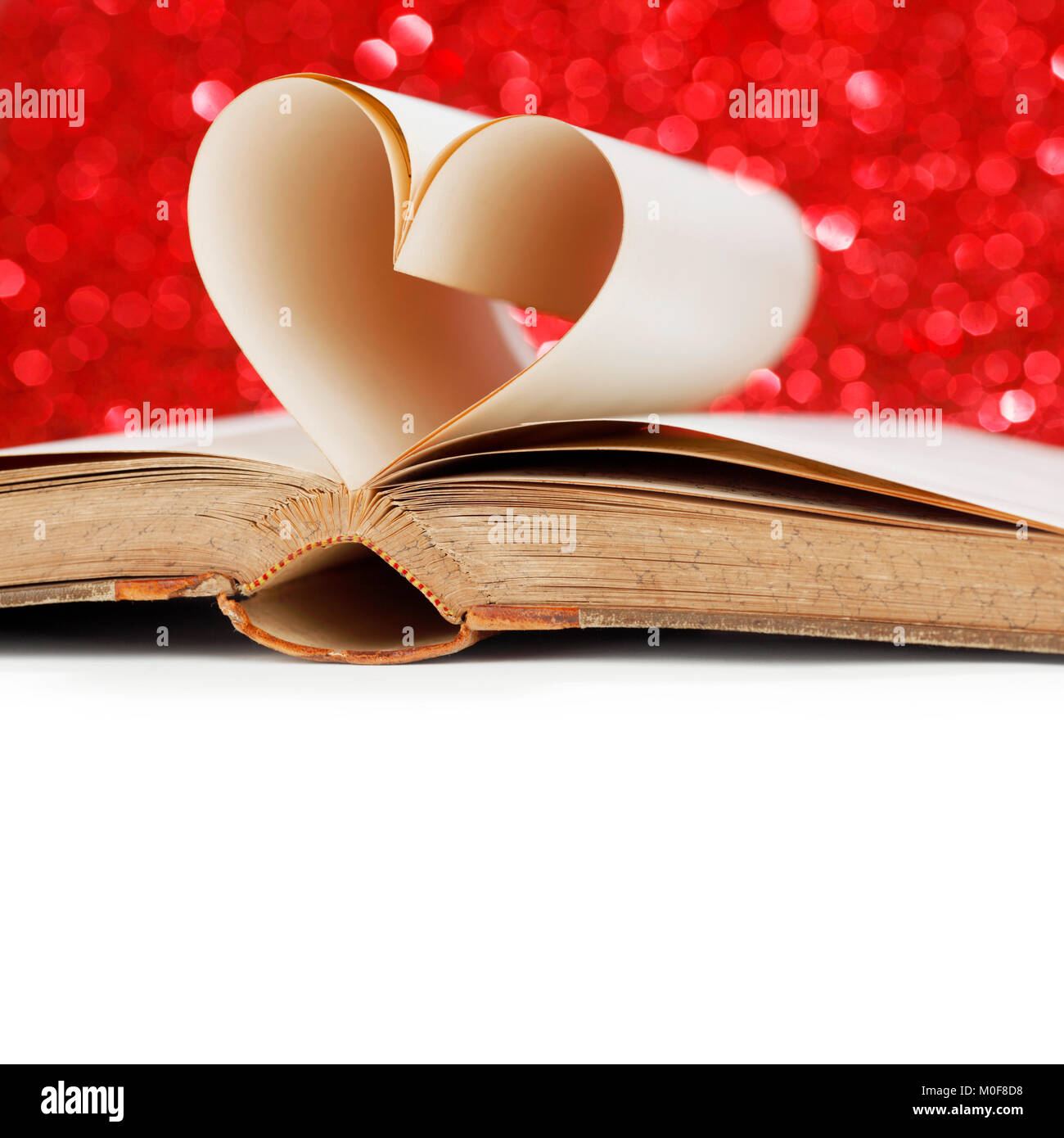 Pages of open book rolled in heart shape on glitter background Stock ...