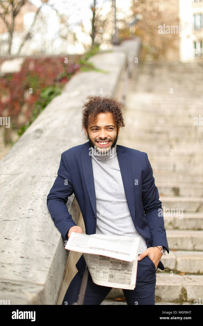 Upset guy reading newspaper outdoor Stock Photo - Alamy