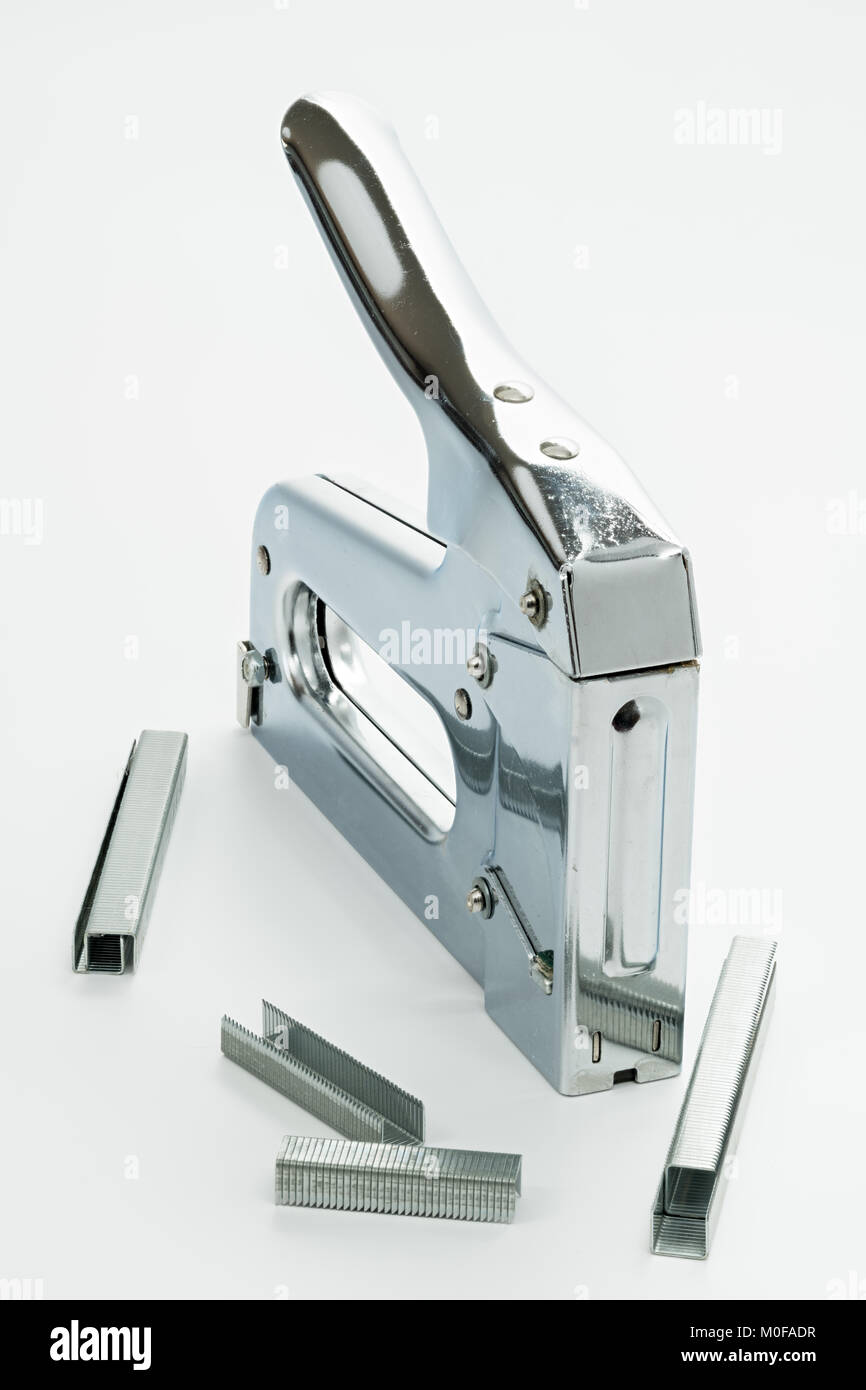 Strip of staples and silver gun for doing construction Stock Photo - Alamy