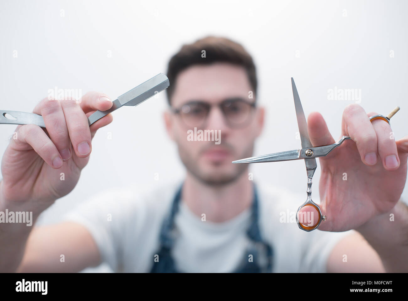 Barber keeps scissors and a razor against the background of a white ...