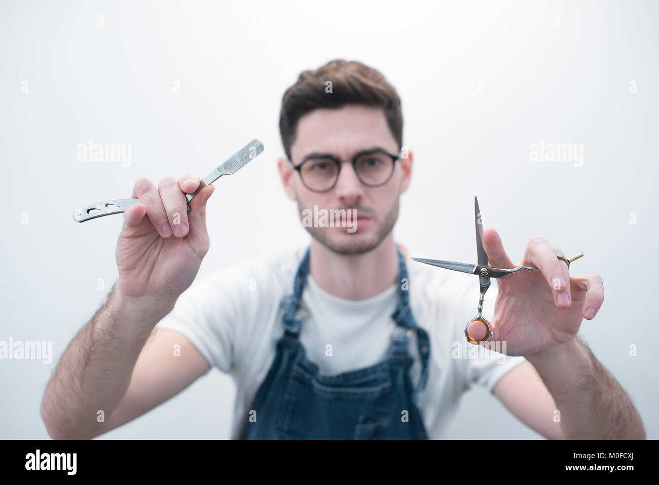 Barber keeps scissors and a razor against the background of a white ...