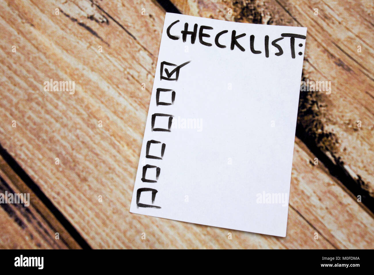 Close up of pin and to do list Checklist word on sticky note and wooden ...
