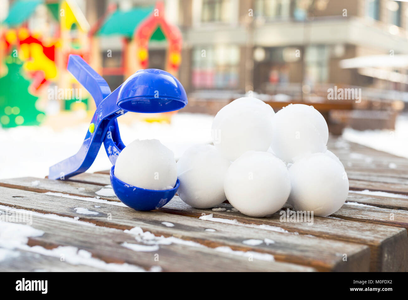 Blue plastic snowball maker tool with set of ready snowballs laying on ...