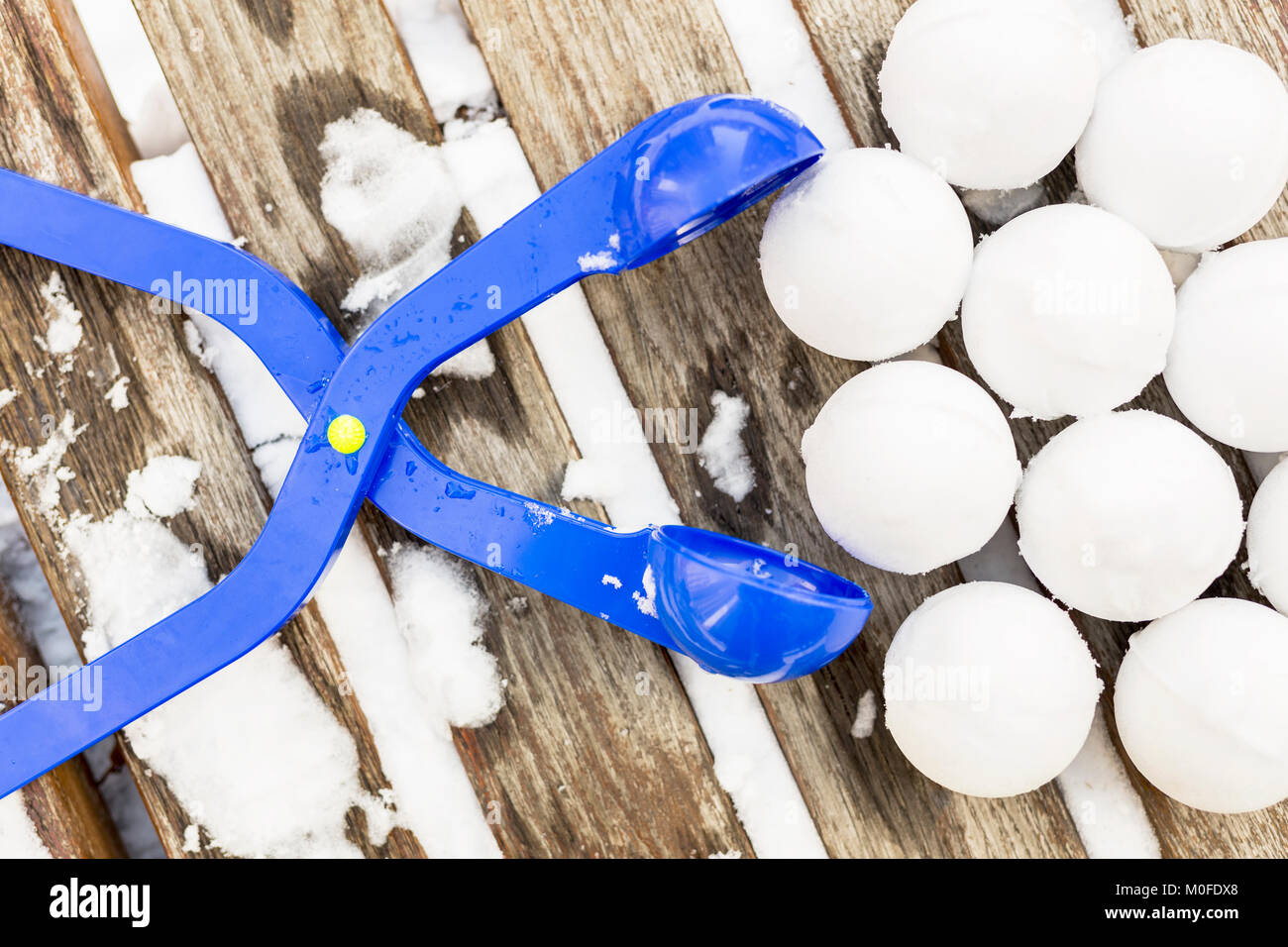 Blue plastic snowball maker tool with set of ready snowballs laying on ...