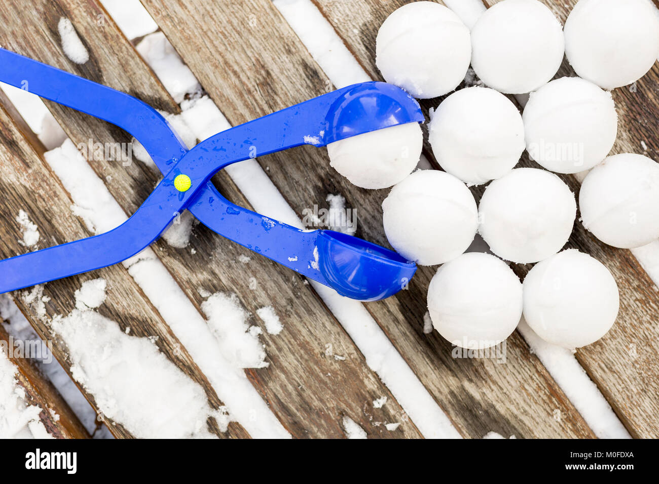 Blue plastic snowball maker tool with set of ready snowballs laying on ...