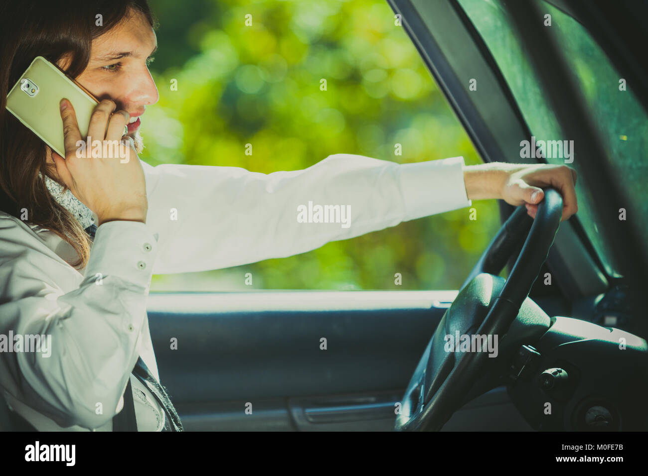 Talking while drive, danger fresh driver concept. Young man driving car ...