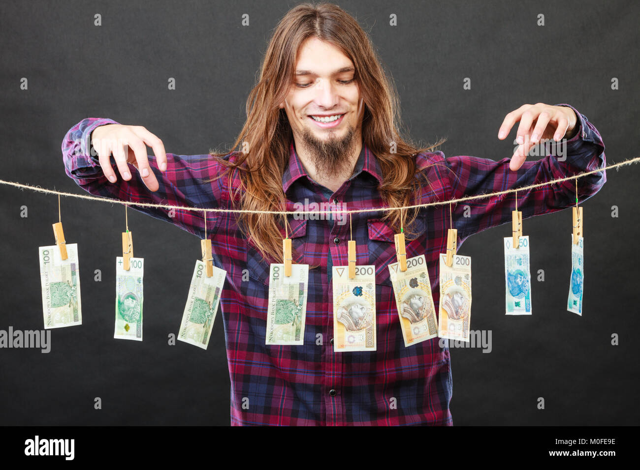 Riches and fortune. Young happy man with a lot of money on black ...