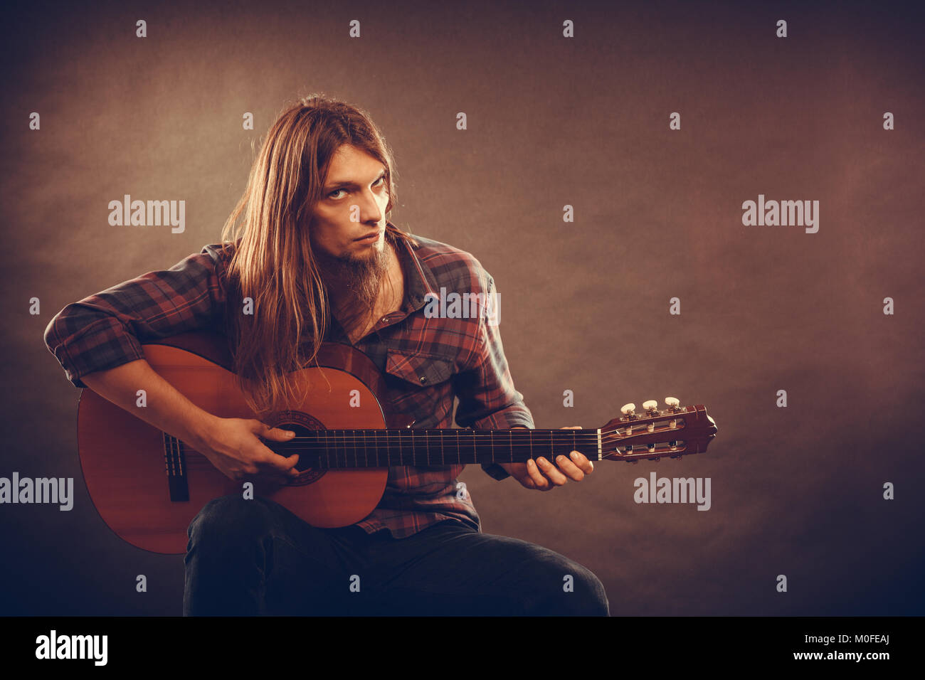 Hobby passion concept. Guitarist is playing the guitar. Long haired ...